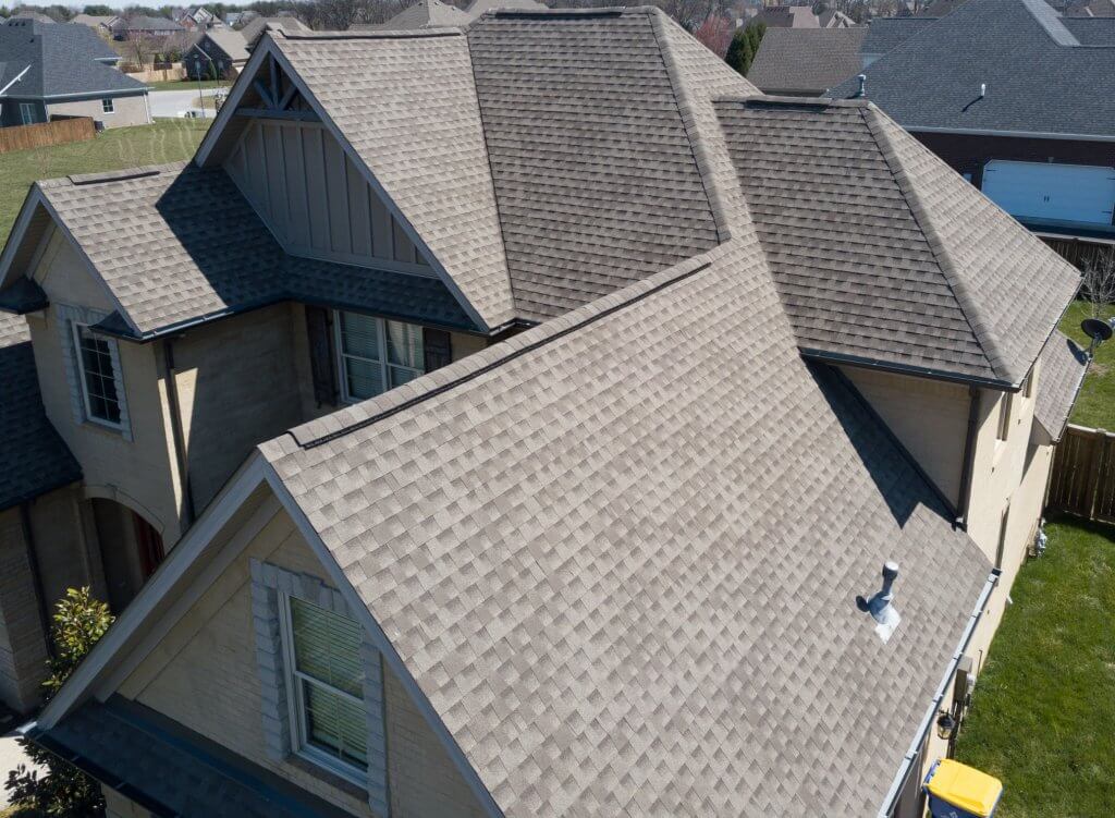 Why is it better to treat a building's whole roof at one time?